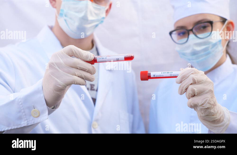 Male and female doctors holds test tube with blood sample to ...