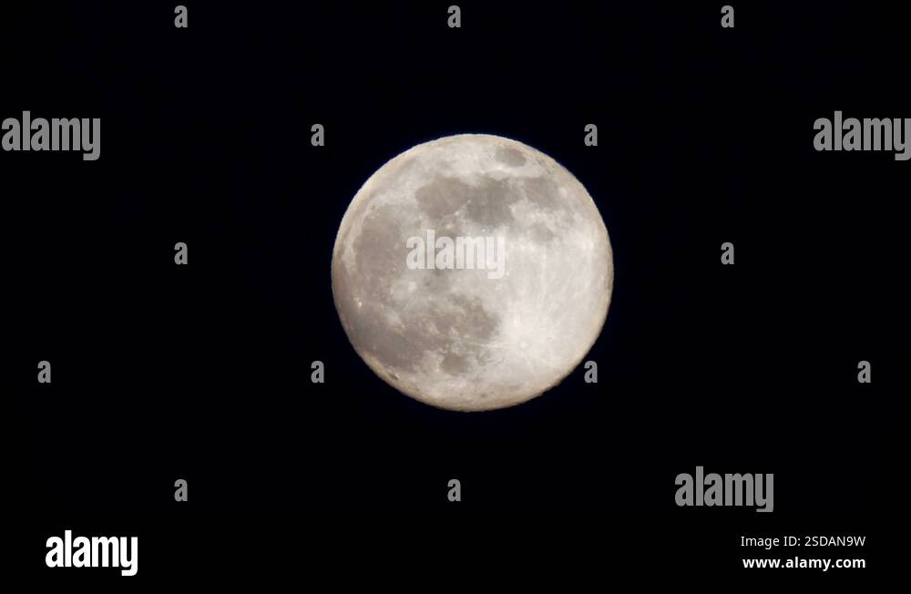 Real Full Moon zoomed in close, moving slowly across dark blue sky ...