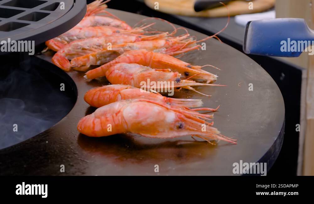Slow motion: chef grilling fresh red king prawns on brazier - close up ...