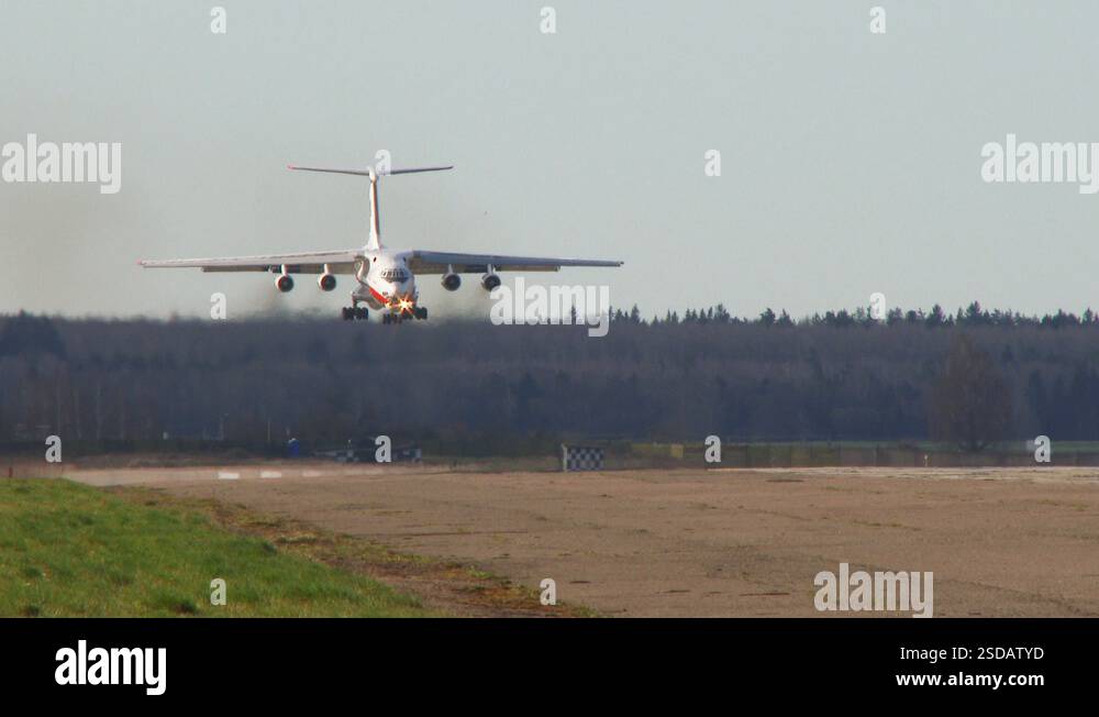 A frontal shot of an airport landing strip with a plane, going down ...