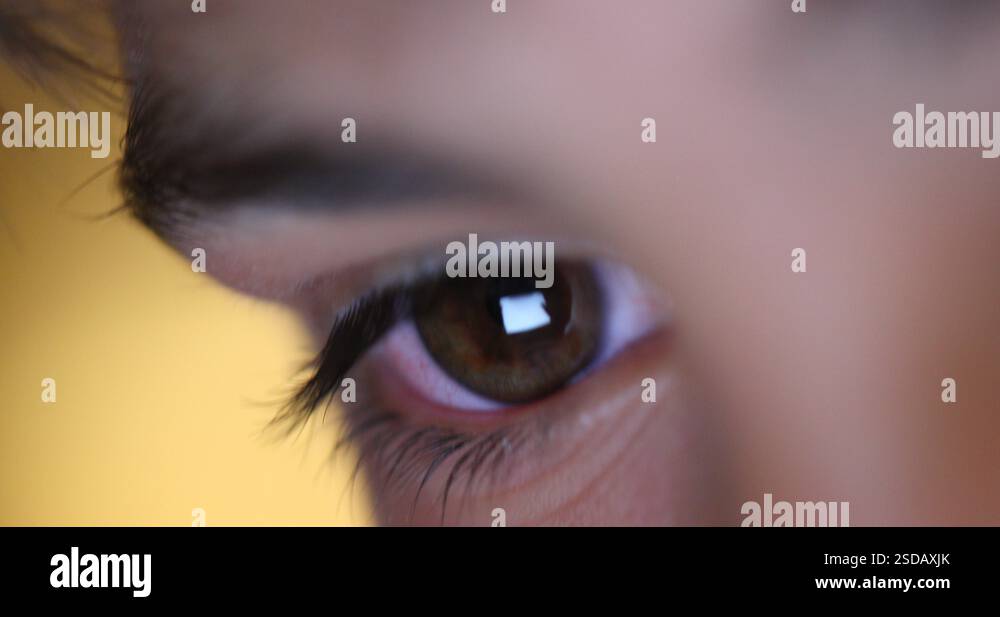 Close-up of child eyes staring at screen. Macro red eye looking at blue ...