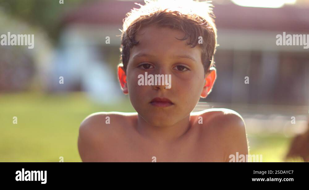 Handsome young boy staring to camera outside in nature. Portrait of ...