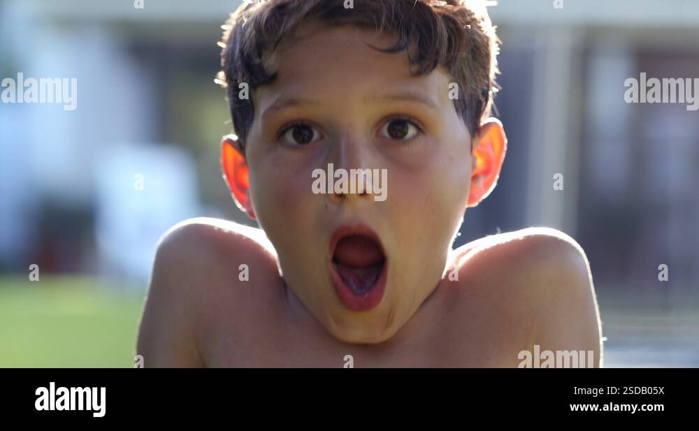 Young boy reaction in shock and astonishment to camera. Kid reacting to ...