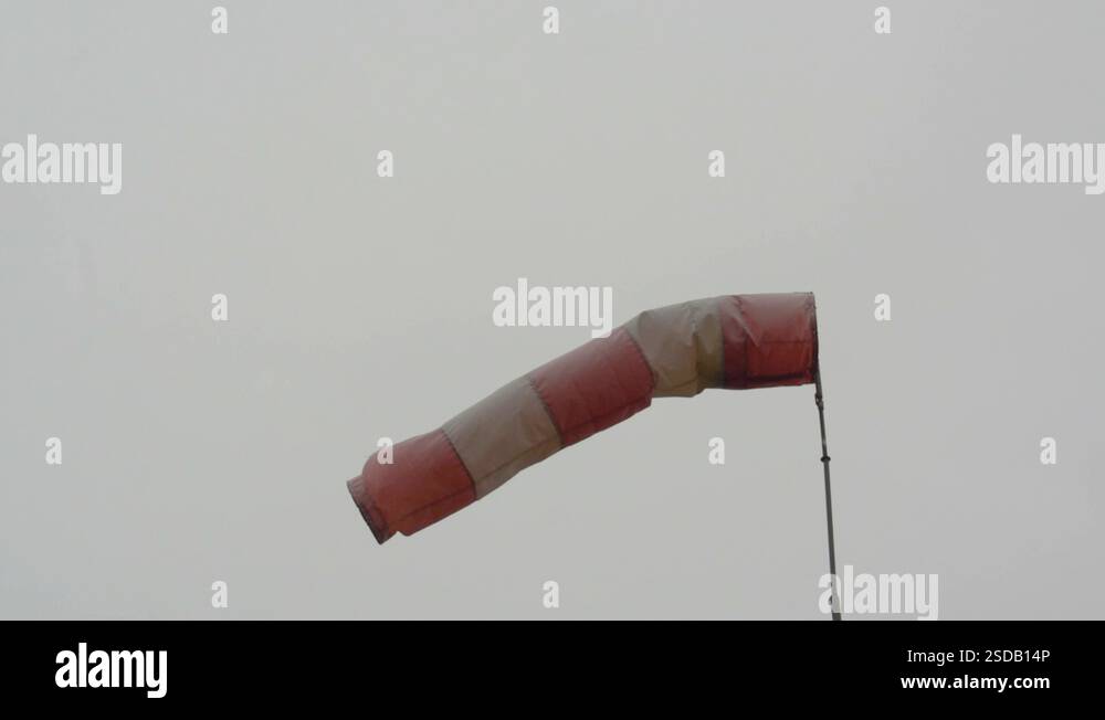 Close up to a white and red colored windsock moved by the wind Stock ...