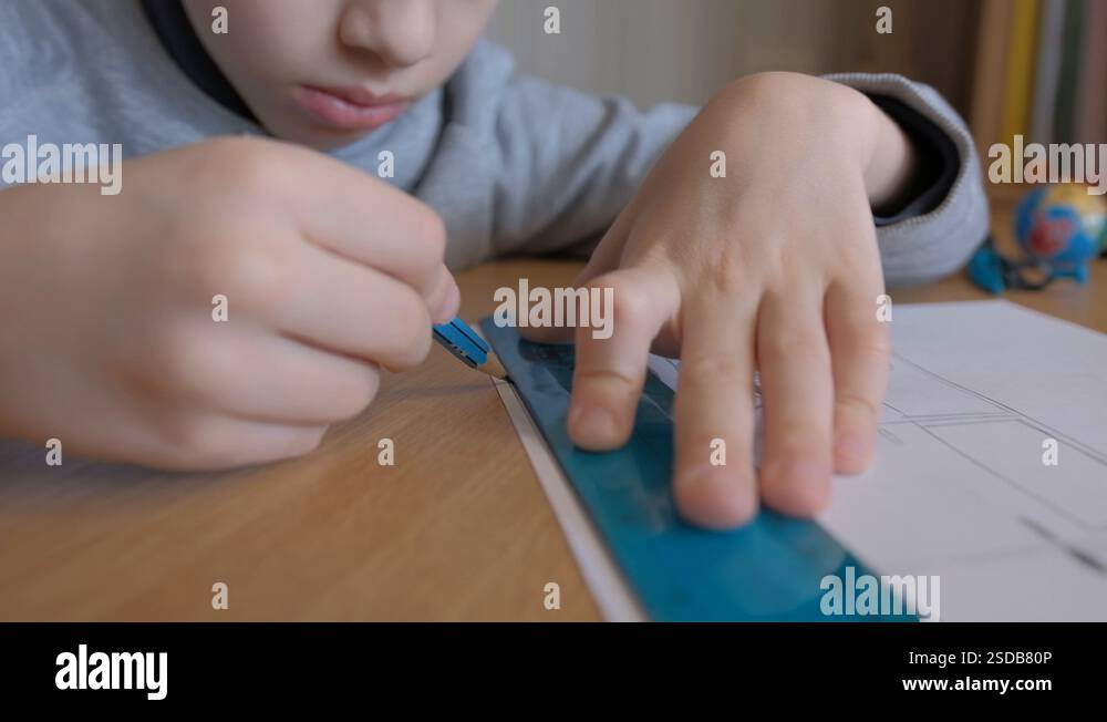 Schoolboy make homework and using drawing compass and ruler to draw a ...