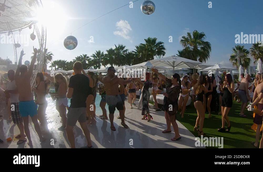Party people shaking, spraying and popping bottle champagne to ...