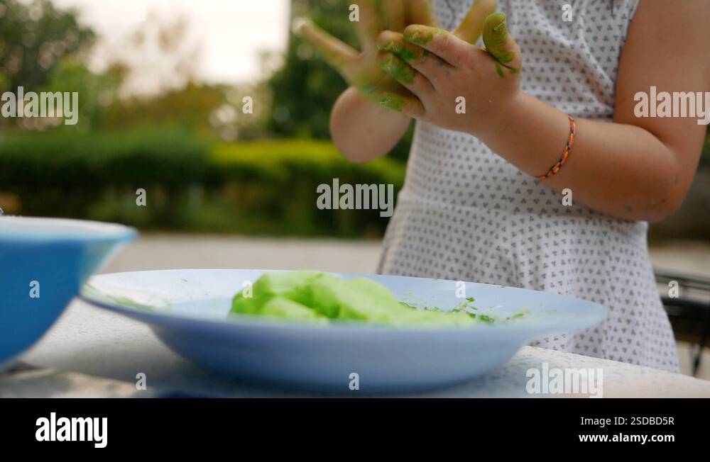 Child girl preparing green glutinous rice dough and make Bualoy balls ...
