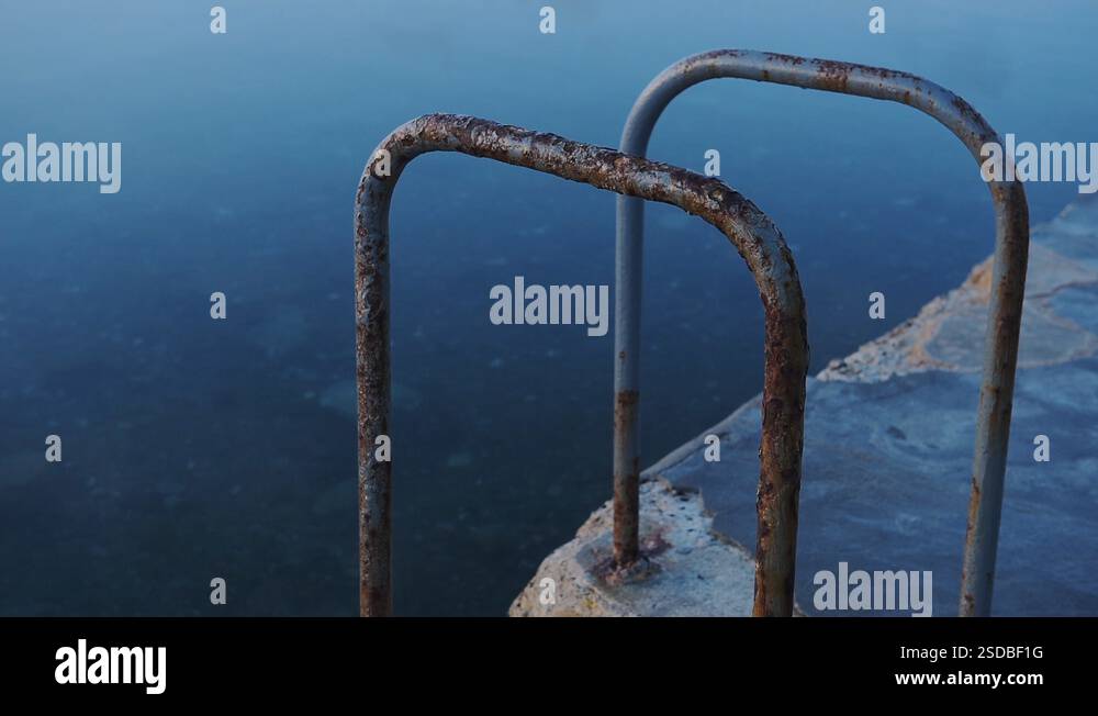 Rusted stairs in an outdoor swimming pool, in the Guernsey seaside, at ...