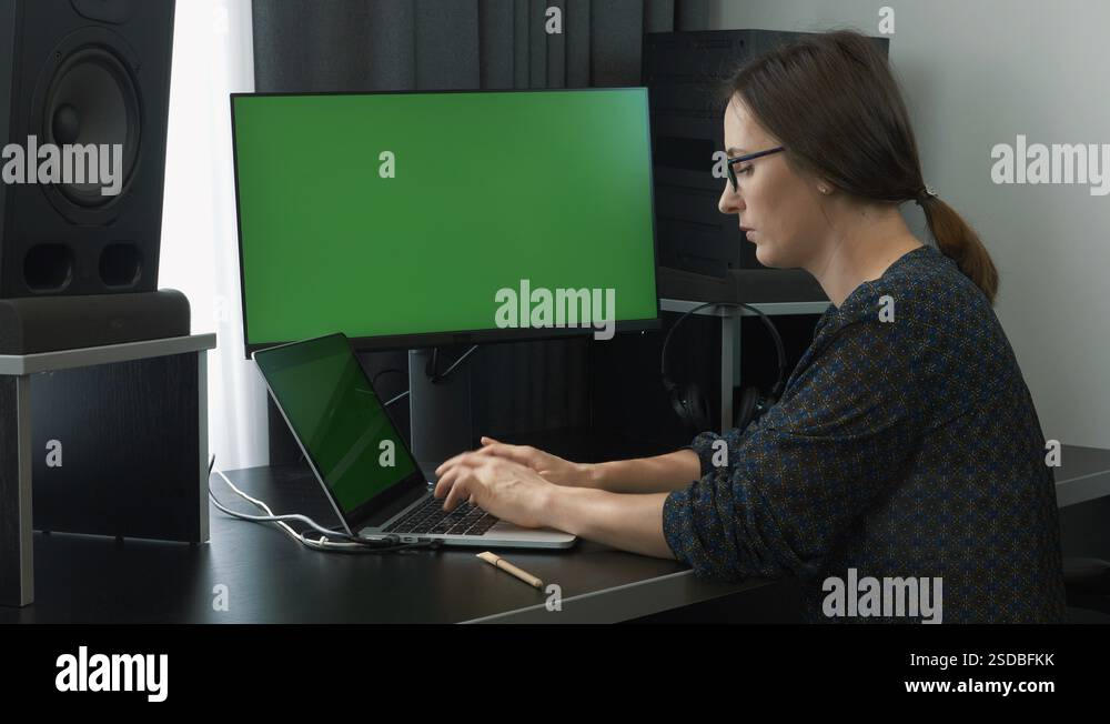 Female employee working on laptop computer from home workplace ...