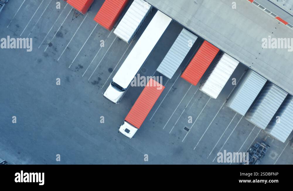 Aerial top down view of semi trucks with cargo trailers standing at the ...