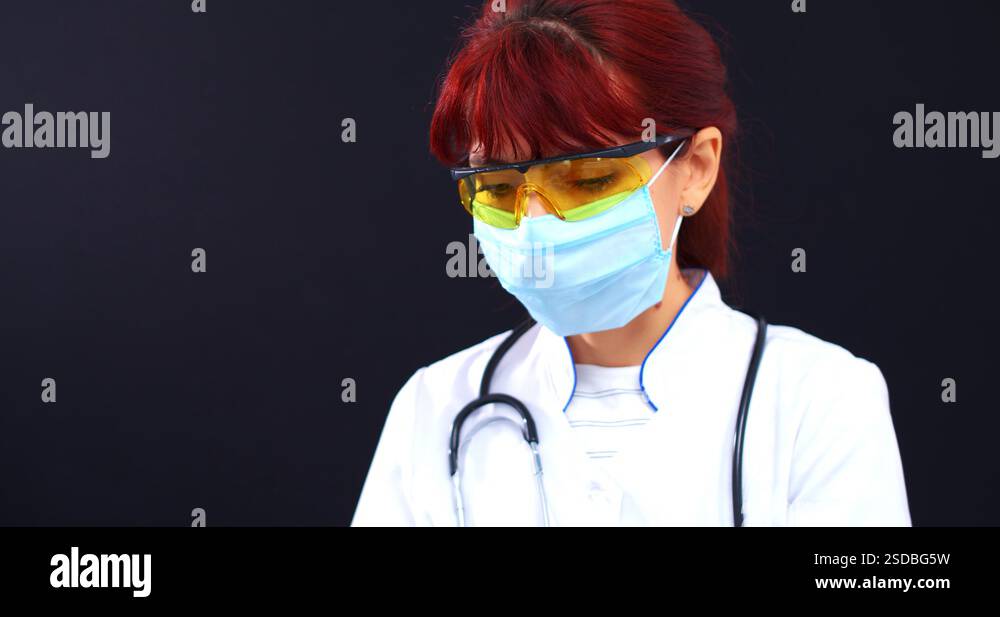 Tired doctor woman face with a mask and safety glasses on black. 4k ...