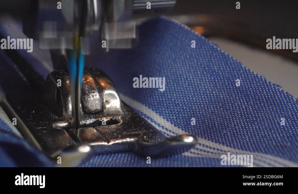 extreme macro shot, a zig zag seam with a sewing machine on blue fabric ...