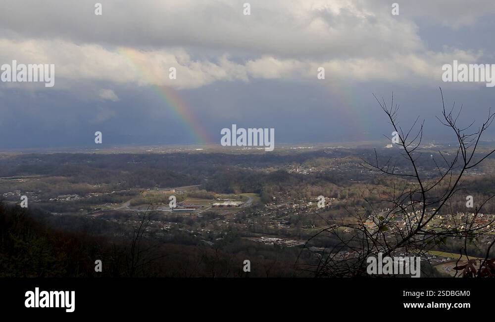 Overlooking a valley as clouds roll through and a double rainbow ...
