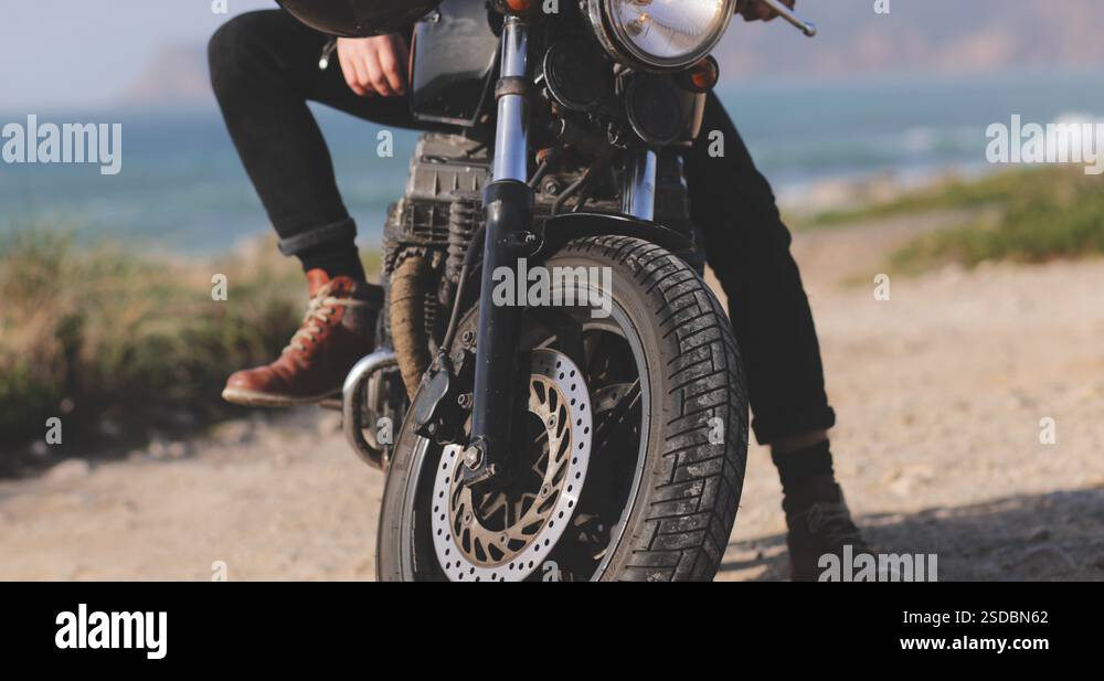 Handsome man on classic motorcycle, helmet hanging on handle Stock ...