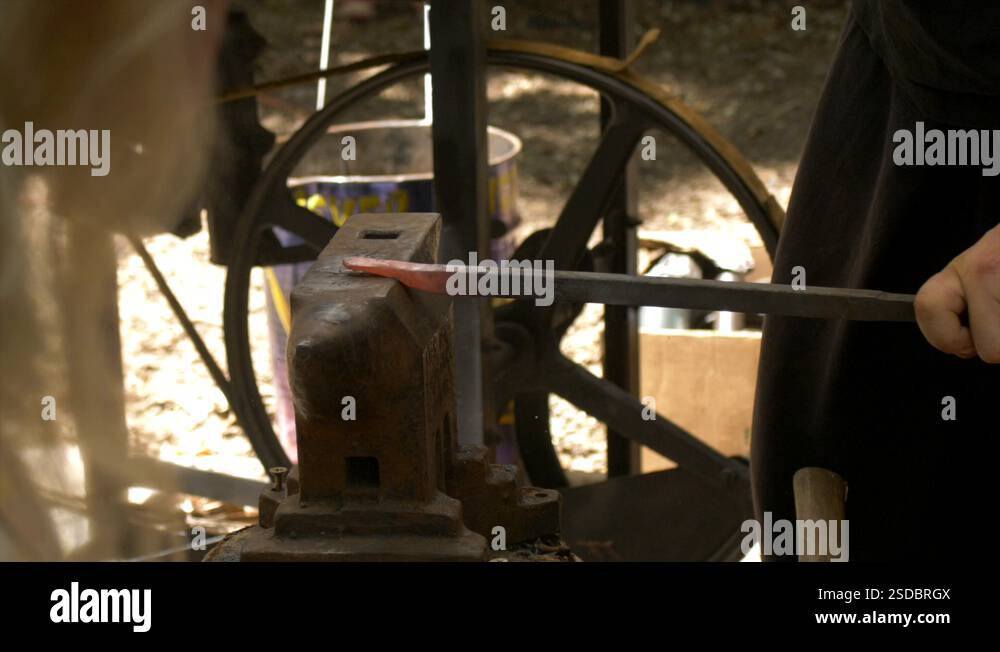 Blacksmith hitting red hot iron stick with hammer hard, slow motion ...