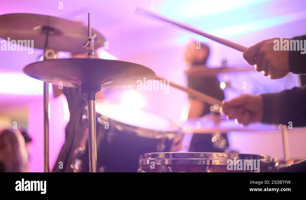 The drummer plays the cymbals at a concert. The drummer hits the plate ...