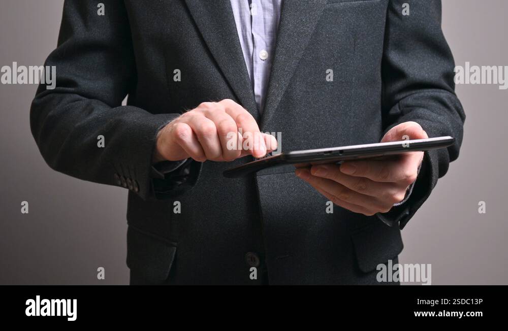 Caucasian male swiping the tablet screen and reading the news feed ...