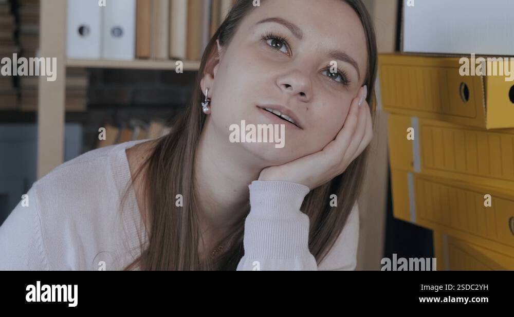 Girl put her head in her palm, smiles, looks into distance, break in ...