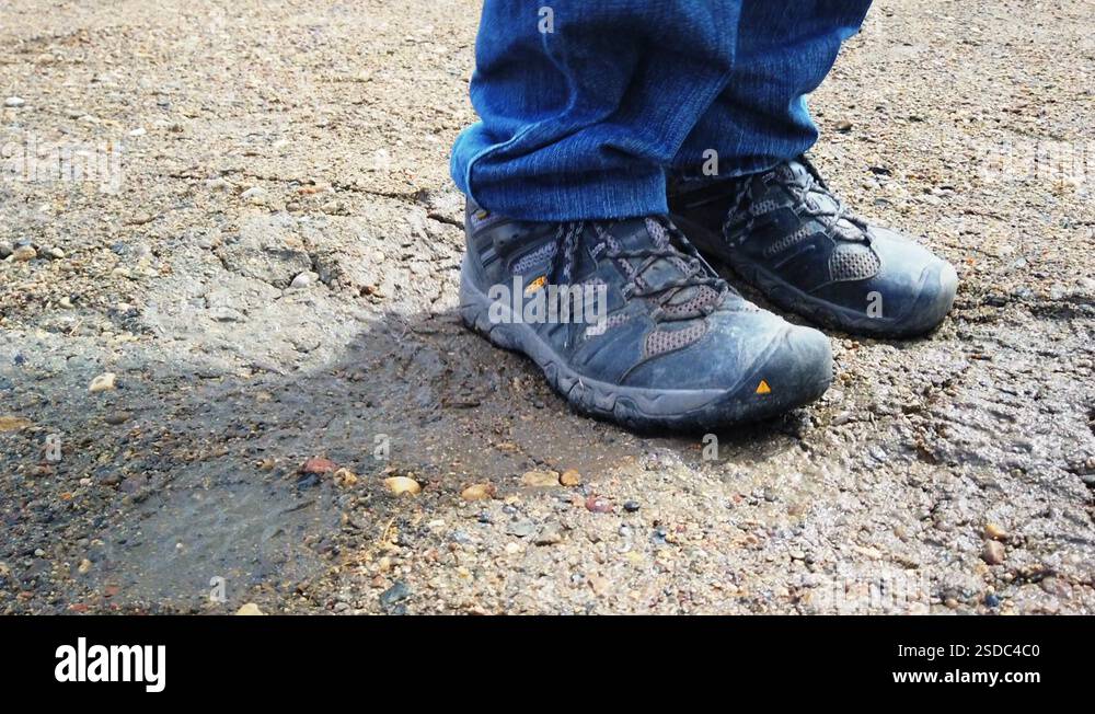 Man walks on frost boils in farm yard during spring thaw Stock Video ...