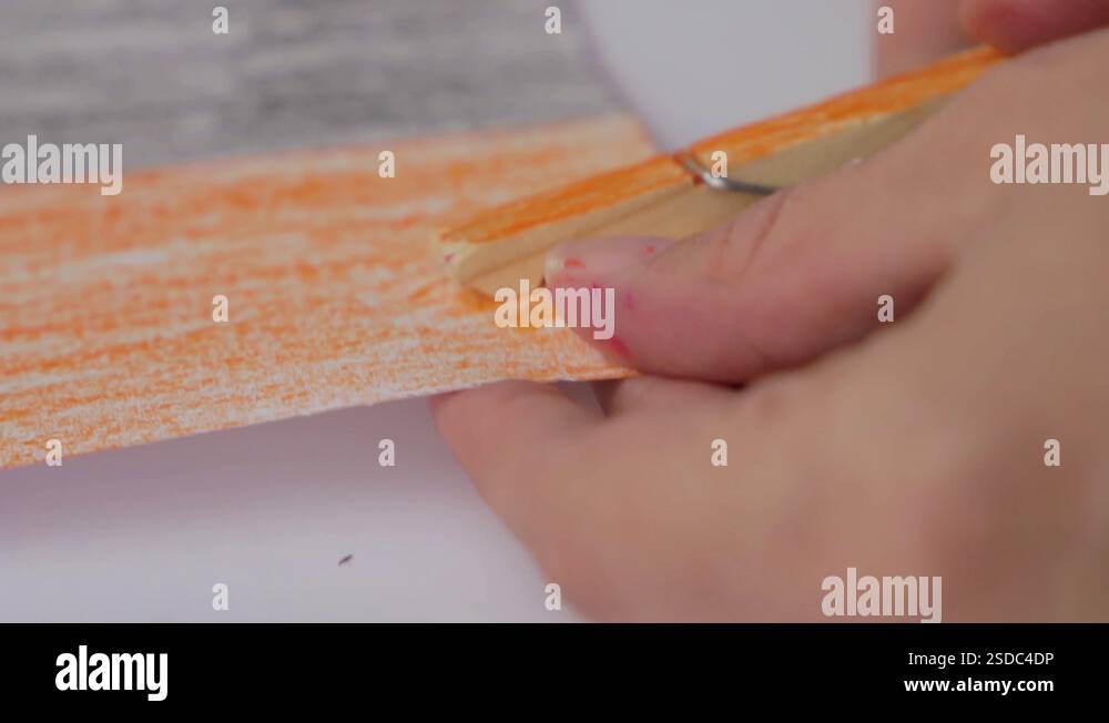 Close up of a Woman clipping a colored clothing peg to a piece of paper ...
