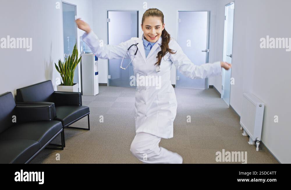 Very excited doctor female dancing in front of the camera in the middle ...