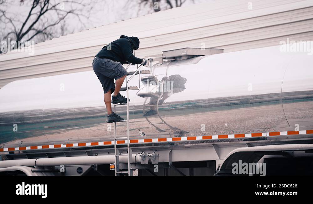 Mechanic climbing down ladder of fuel truck zoom out Stock Video ...