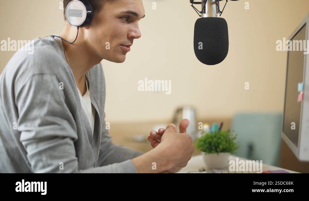 Young man streamer hosts a podcast and answers questions, working at a ...