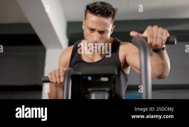 Exercising on stationary bike, man in gym focusing on intense workout ...