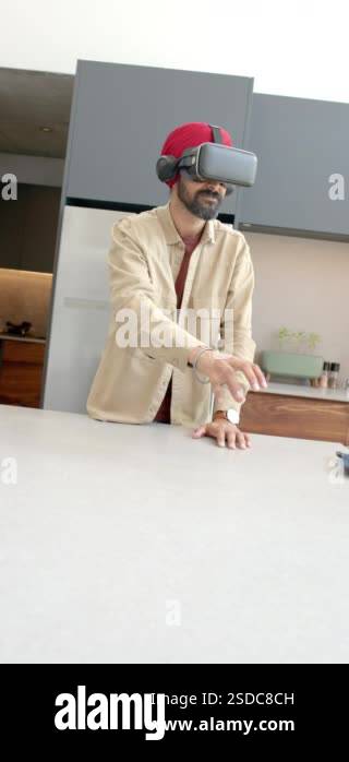 Vertical video: Using VR headset, man in turban interacting with ...