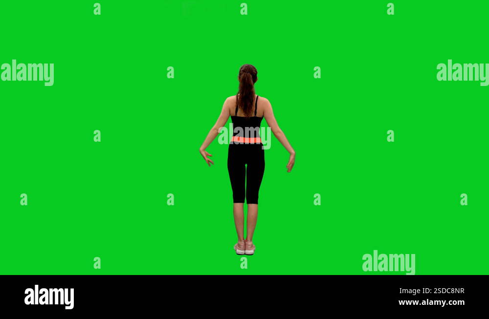 Rear view slim sporty girl doing sports exercises on green screen Stock ...