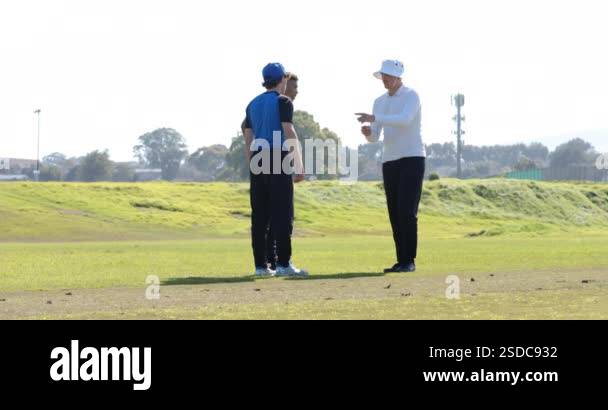Two multiracial male cricket players and male umpire throwing coin and ...
