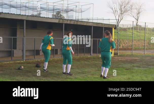 Multiracial female baseball players warming up, doing sidestepping and ...