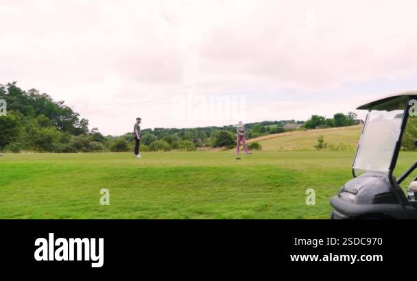 Golf players playing golf together, hitting the ball with club on a ...