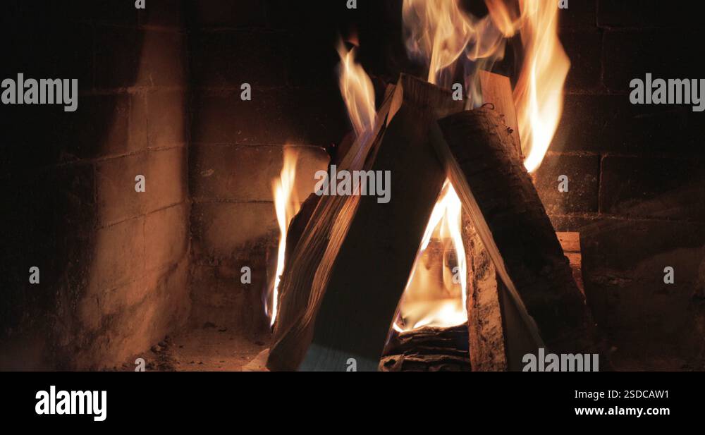 The big fire with firewood in a fireplace, bonfire burning, Brick walls ...