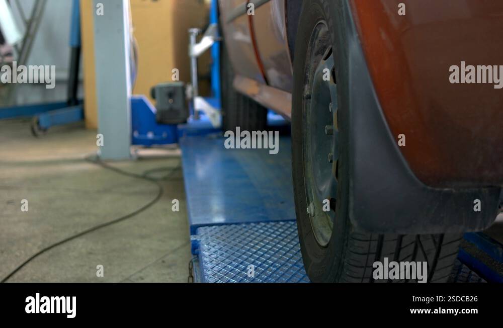 Engineer setting camber caster gauge for checking alignment of tire ...