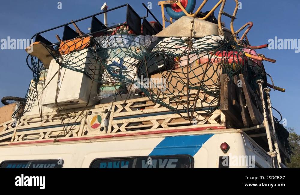 A Van Fully Loaded With Things On Top Travelling By The Riverside In ...