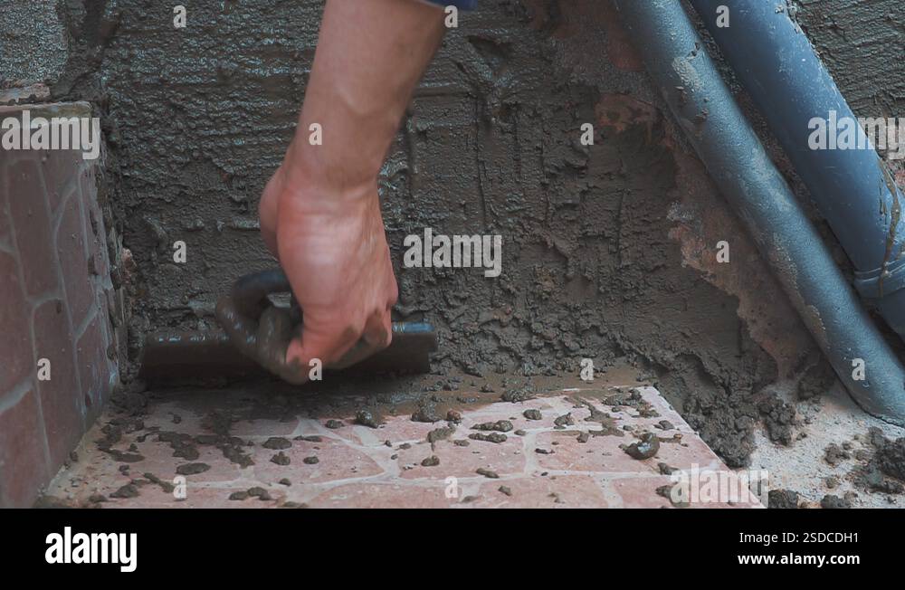 Man's hand plastering a wall insulation and house foundation with ...