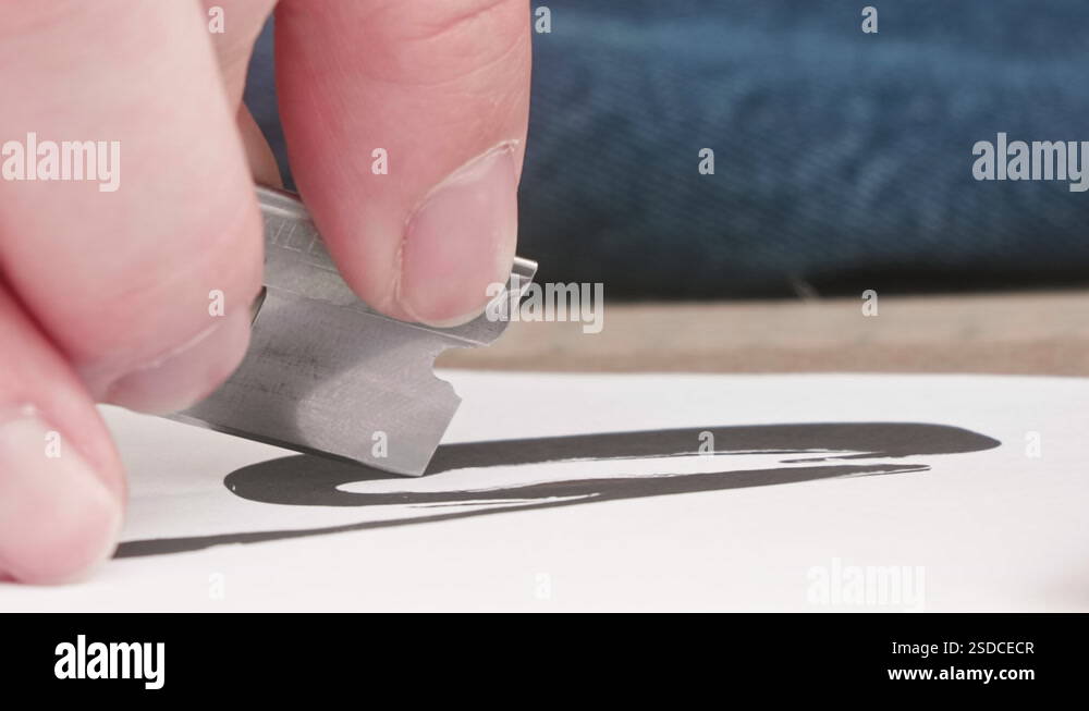 Hands cutting stencil out of paper with razor blade, Extreme Close Up ...