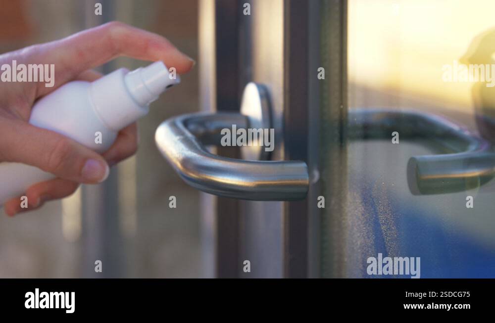hand cleaning doorhandle with disinfectant spray Stock Video Footage ...