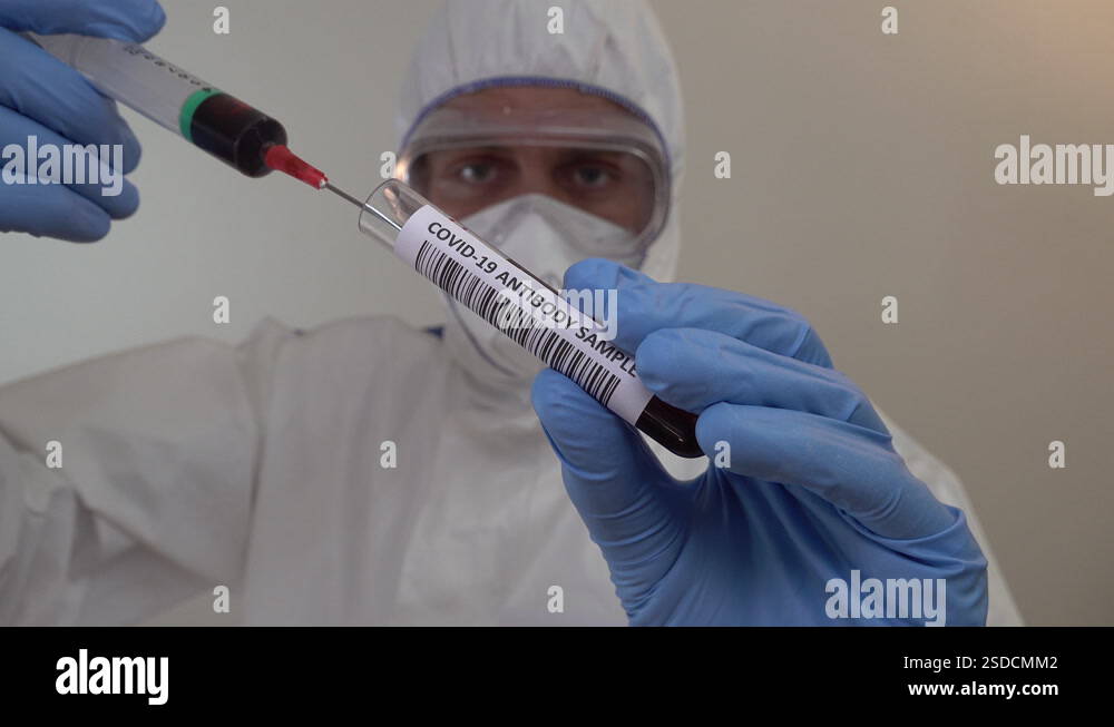 Virology specialist in hazmat suit researching Covid-19 antibody sample ...