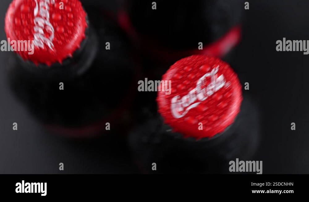 three wet bottles with red coca-cola classic logo rotating and stopping ...