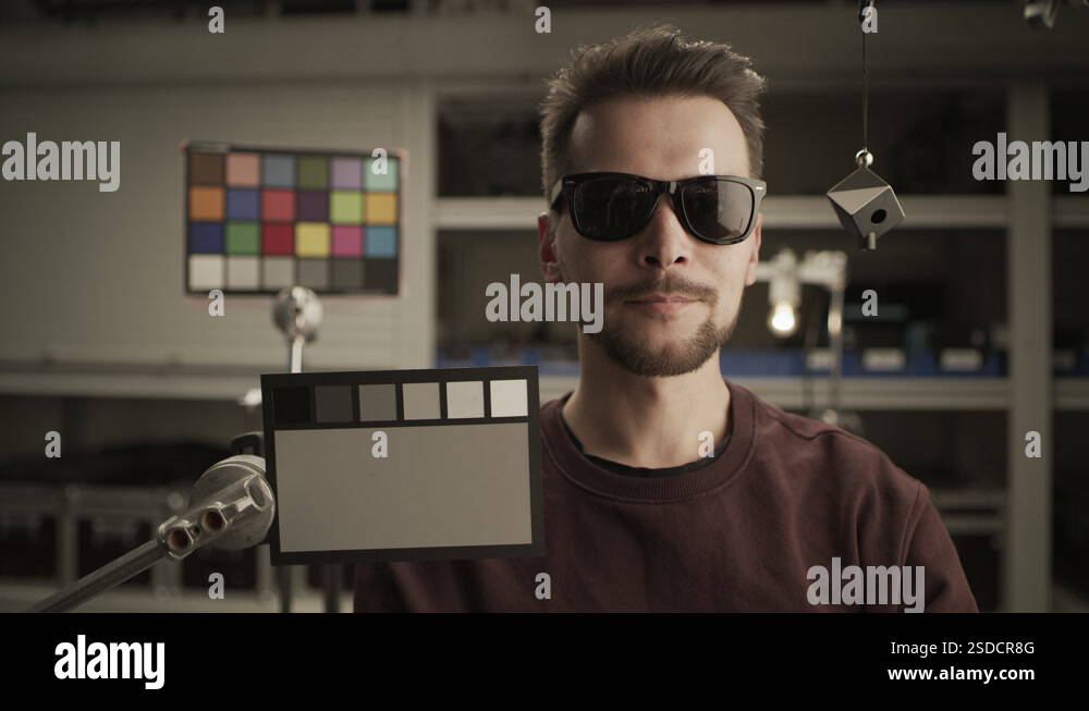 Man in video studio testing professional film camera by Color Checker ...