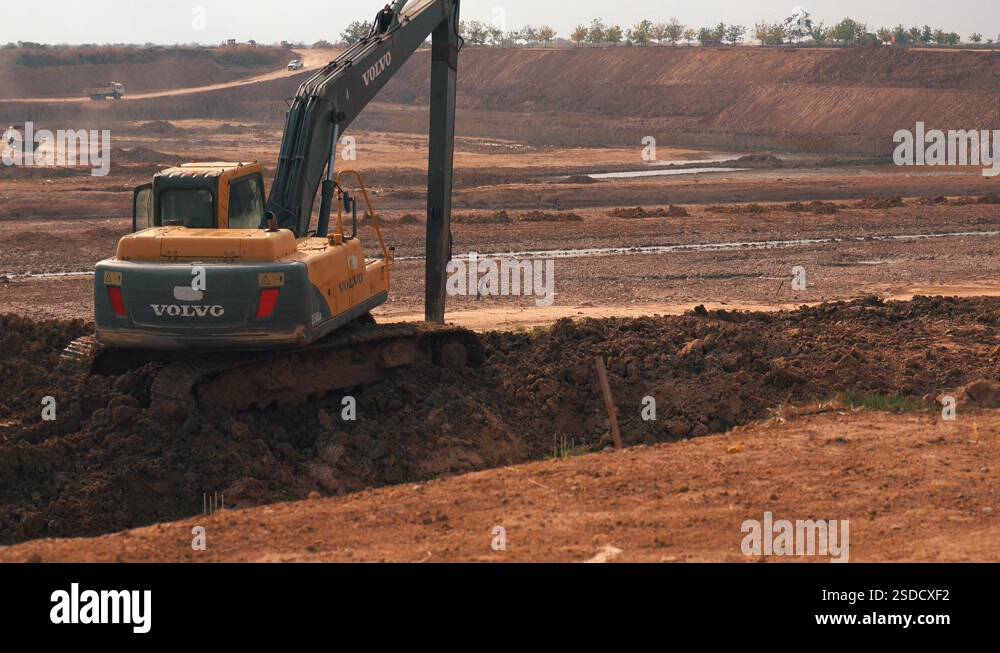 Medium Shot of a Digger Excavating Soil on a Large Construction Site in ...