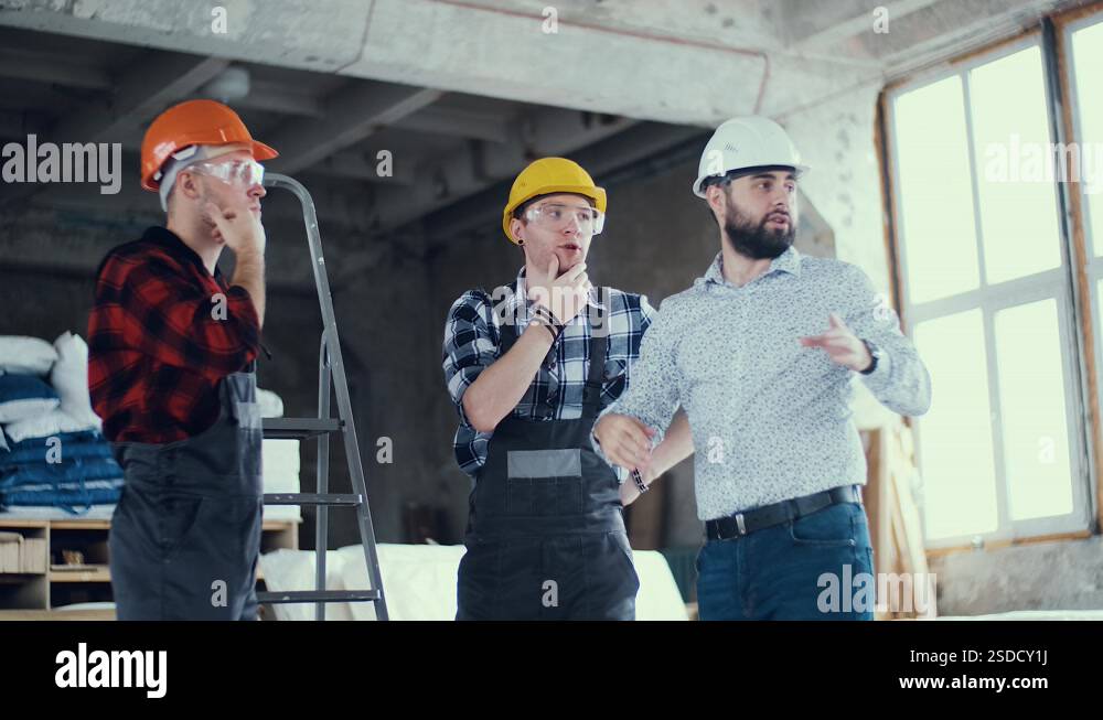 Two builders and a foreman discussing a plan for upcoming work at a ...