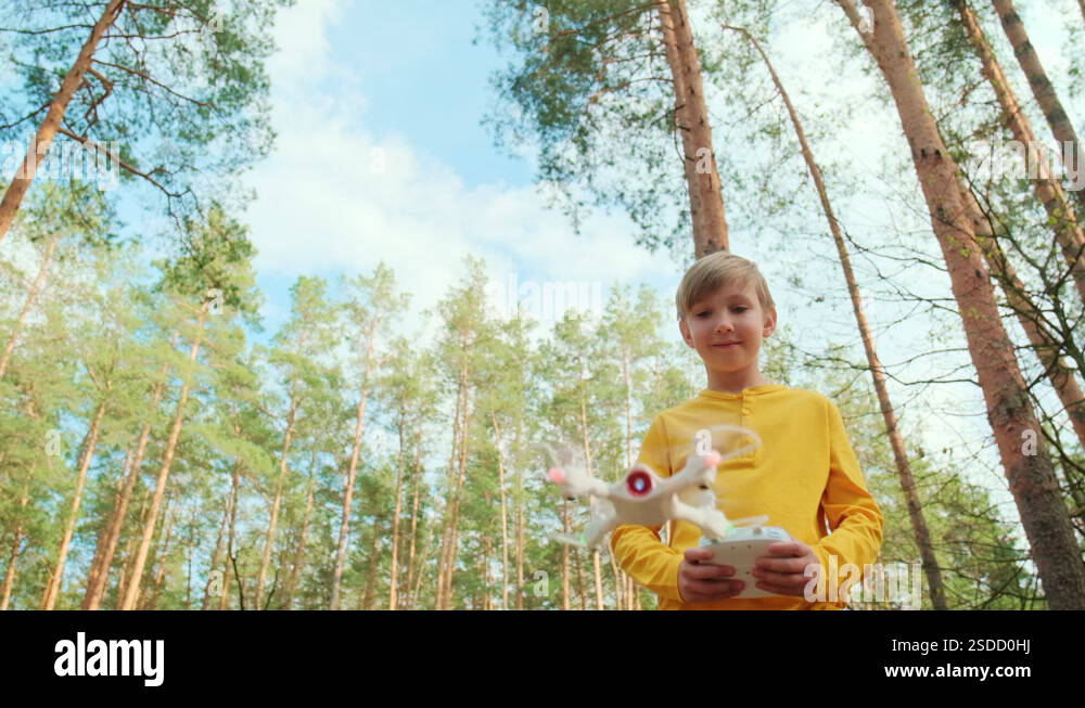 Boy lift off the drone using remote control. Child launches the drone ...