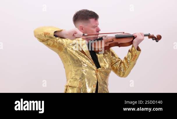 Professional violinist in sparkling golden jacket performs classical ...