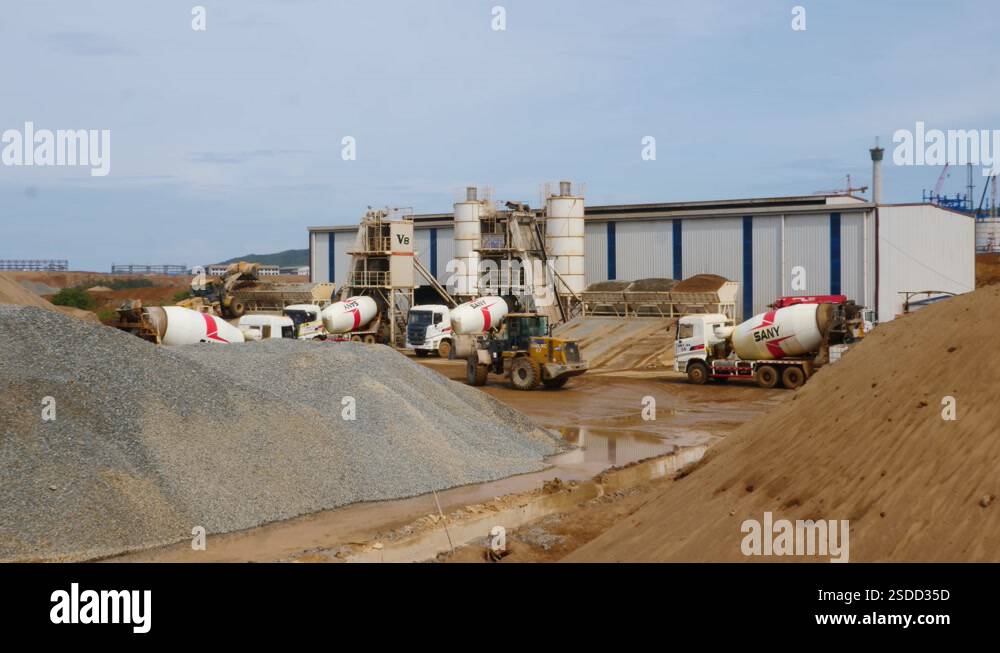 the construction vehicles in the concrete batch plant are busy working ...
