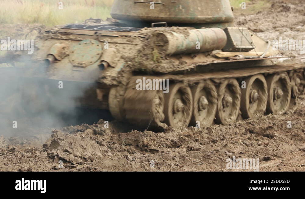 Two Armoured military Tanks driving through mud. Army vehicles ...