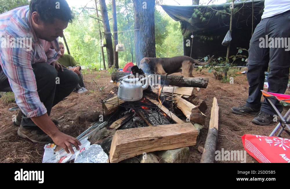 Water boiling over fire in a camp site Stock Video Footage - Alamy