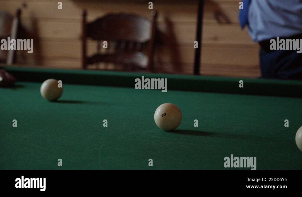 Player hits cue ball billiards, man in shirt approaches pool table in ...